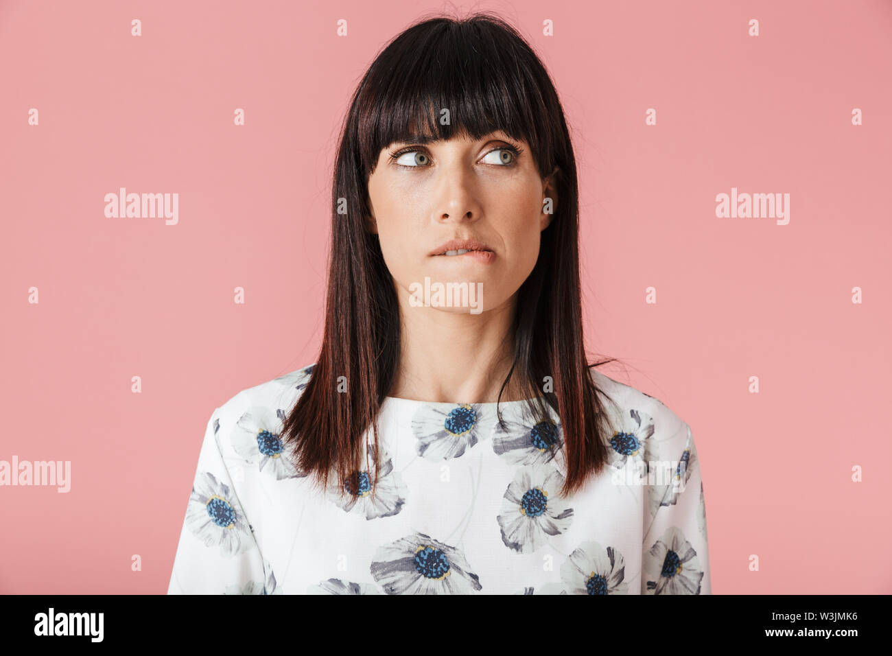 Image of a beautiful thinking young woman posing isolated over pink ...