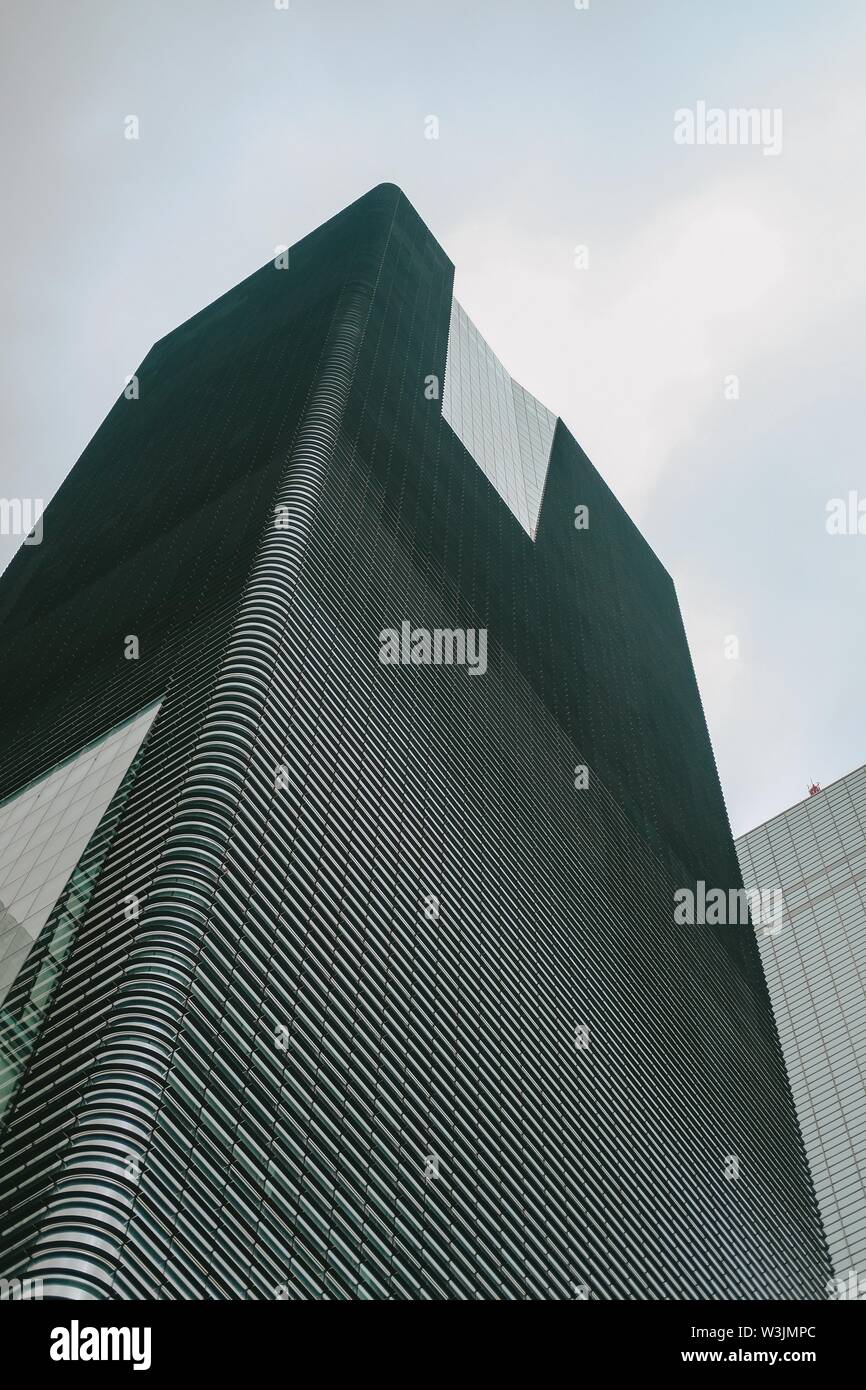 Low angle shot of a tall high-rise modern business building with a ...