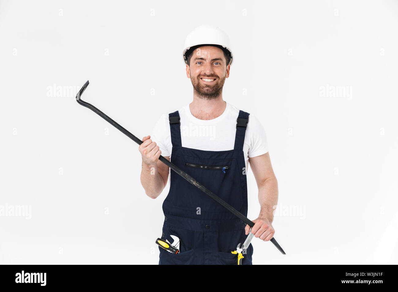 Portrait of a handsome bearded builder man wearing overalls standing ...