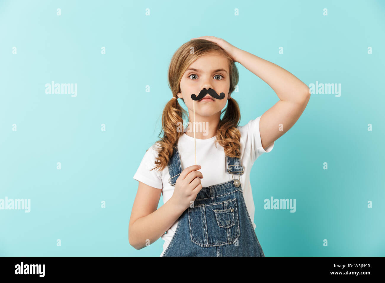 Portrait of a little girl isolated over blue background, having fun ...