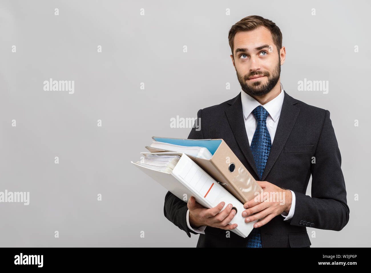 Attractive busy young businessman wearing suit standing isolated over ...