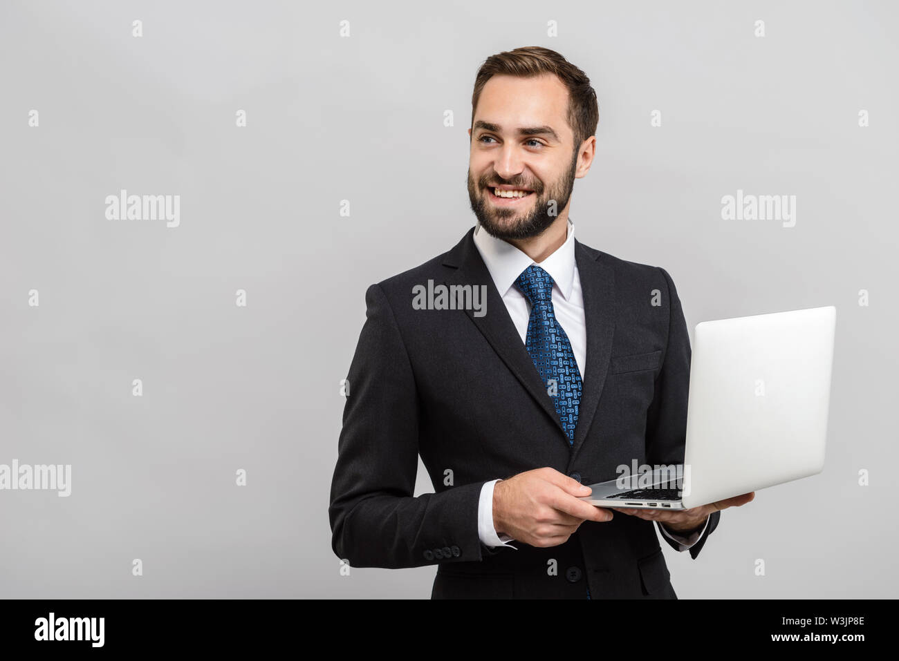 Attractive smiling young businessman wearing suit standing isolated ...