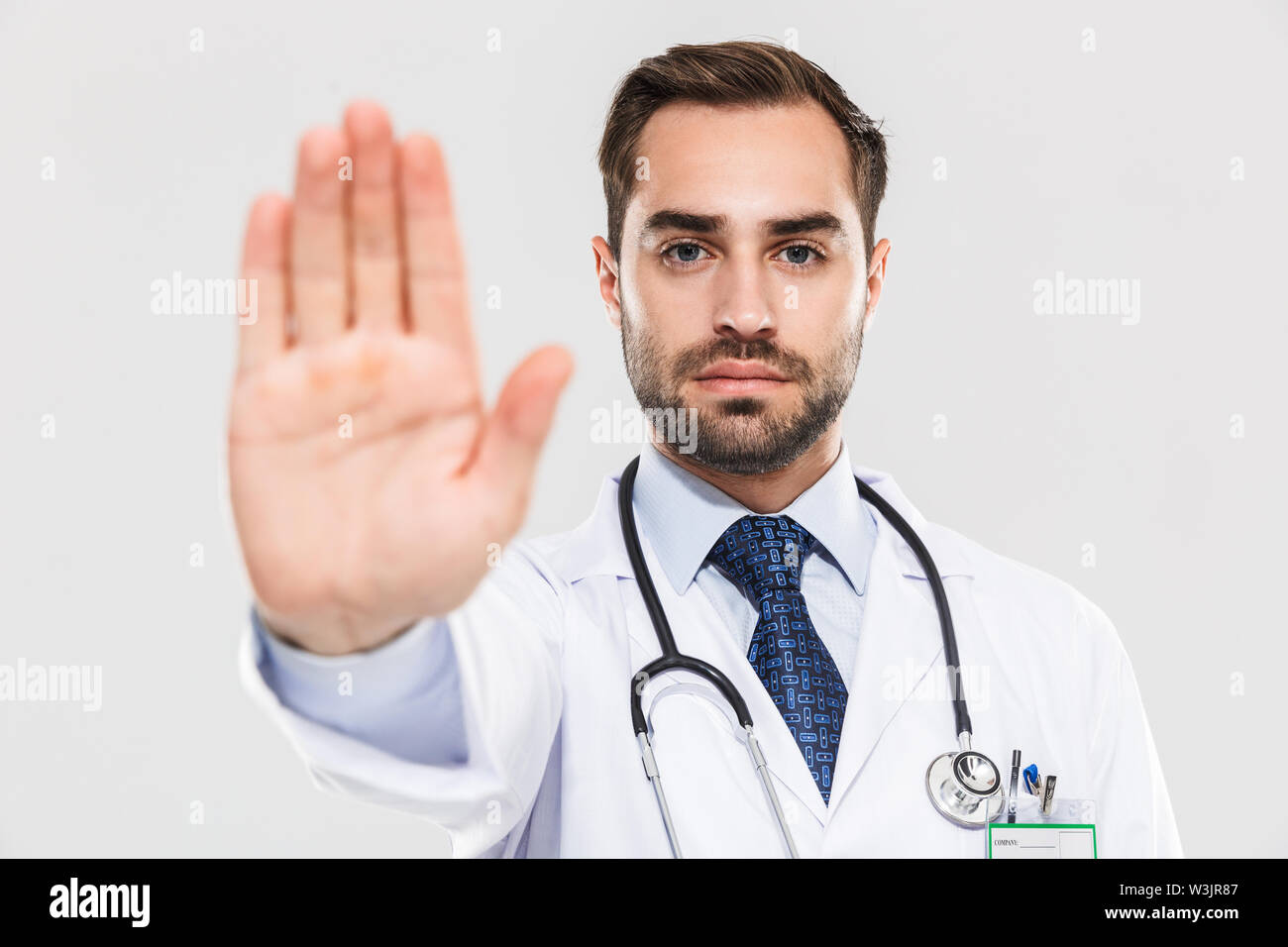 Portrait of confident young medical doctor with stethoscope looking at ...