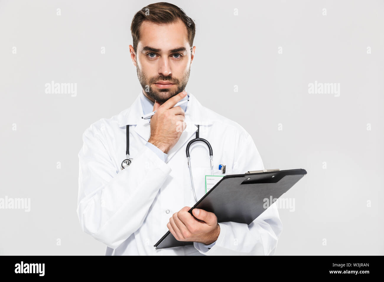 Portrait of professional young medical doctor looking at camera and ...
