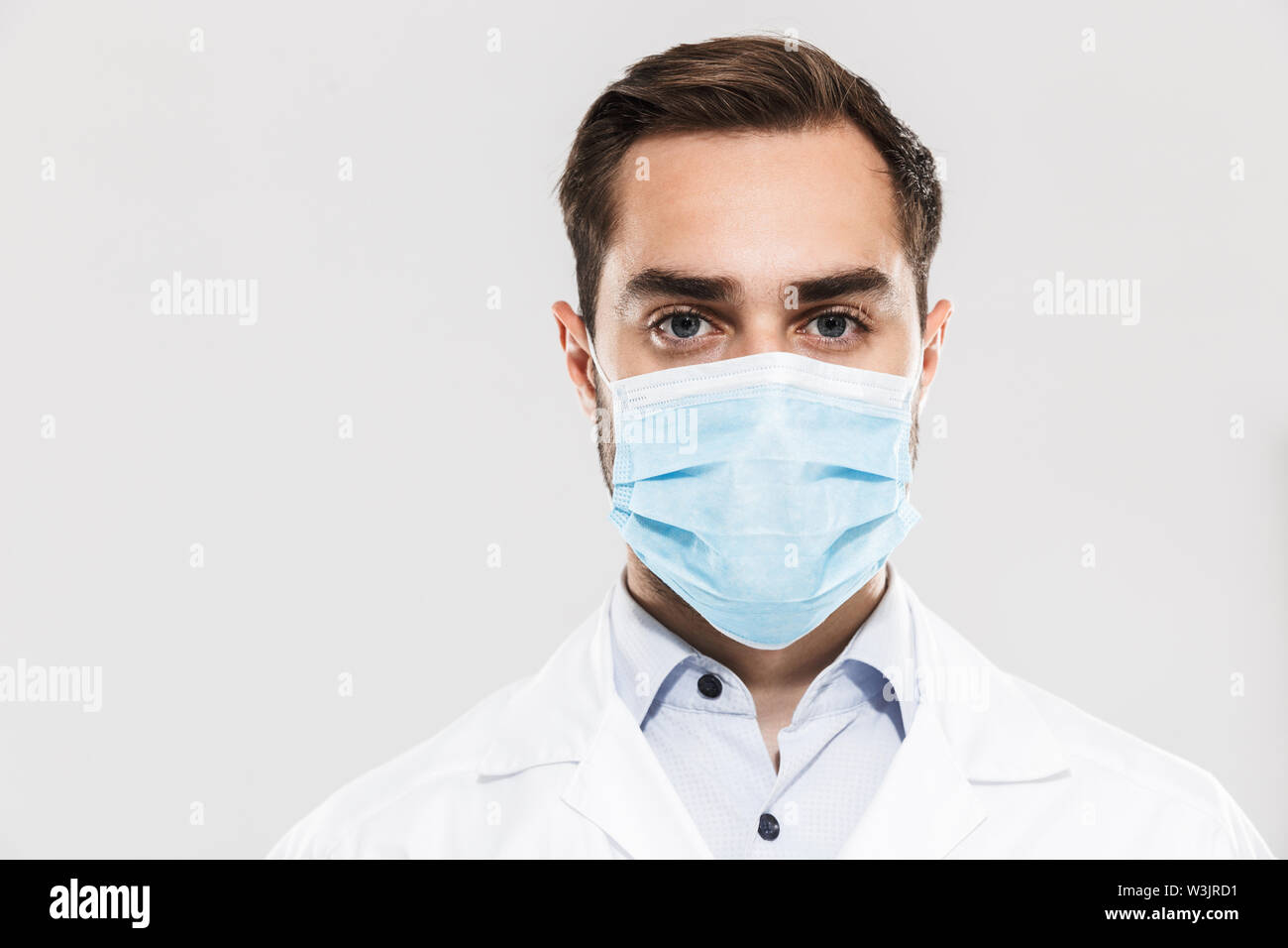 Portrait of european young medical doctor wearing sterile mask working ...