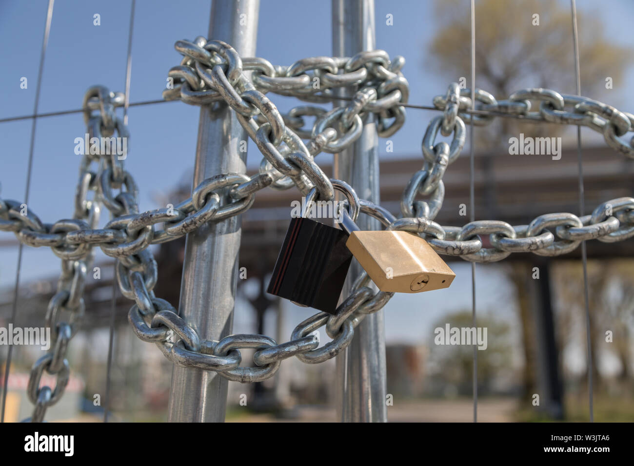 steel fence locked with chain and padlocks Stock Photo - Alamy