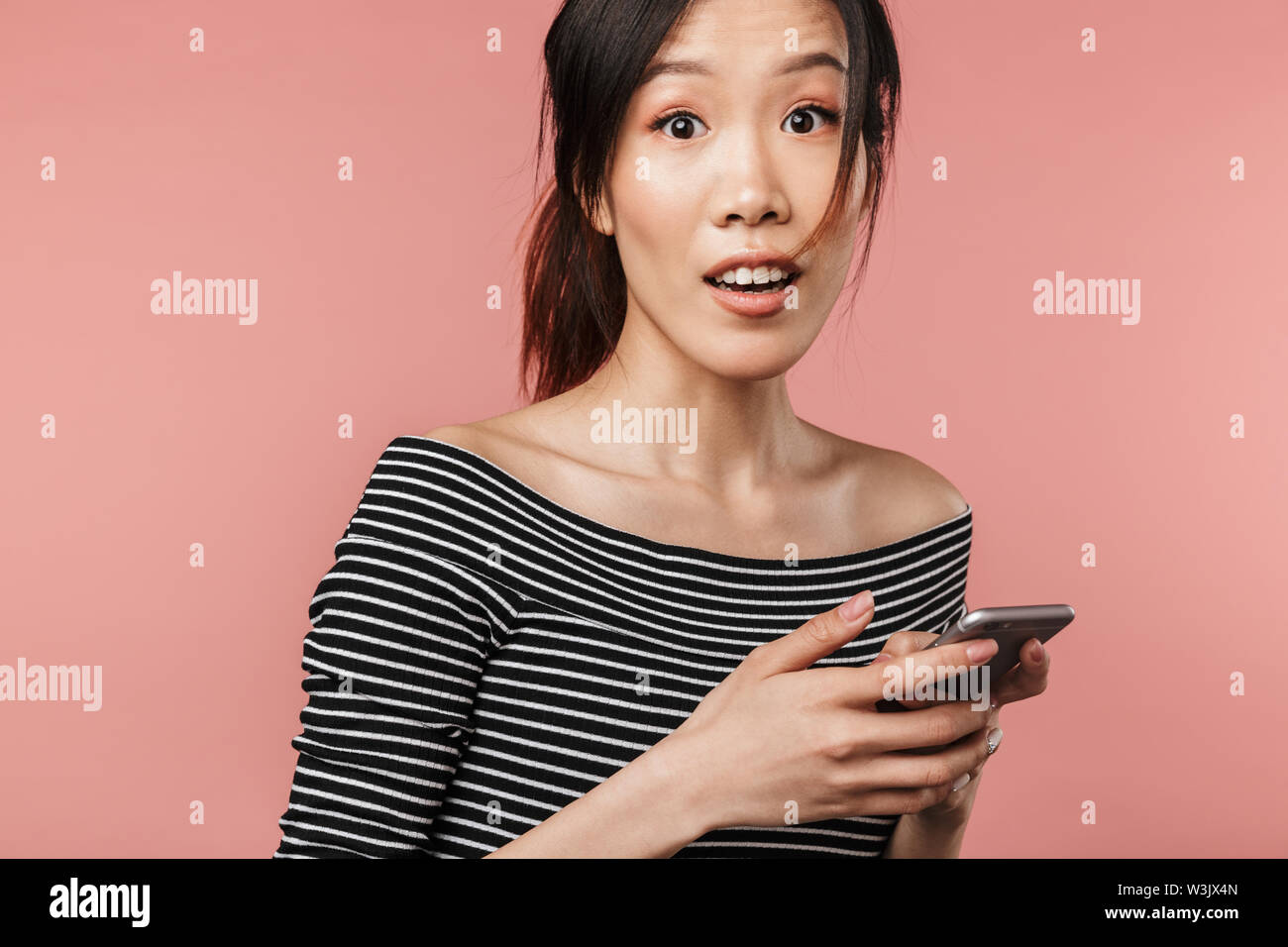 Photo of brunette asian woman dressed in basic wear expressing surprise ...