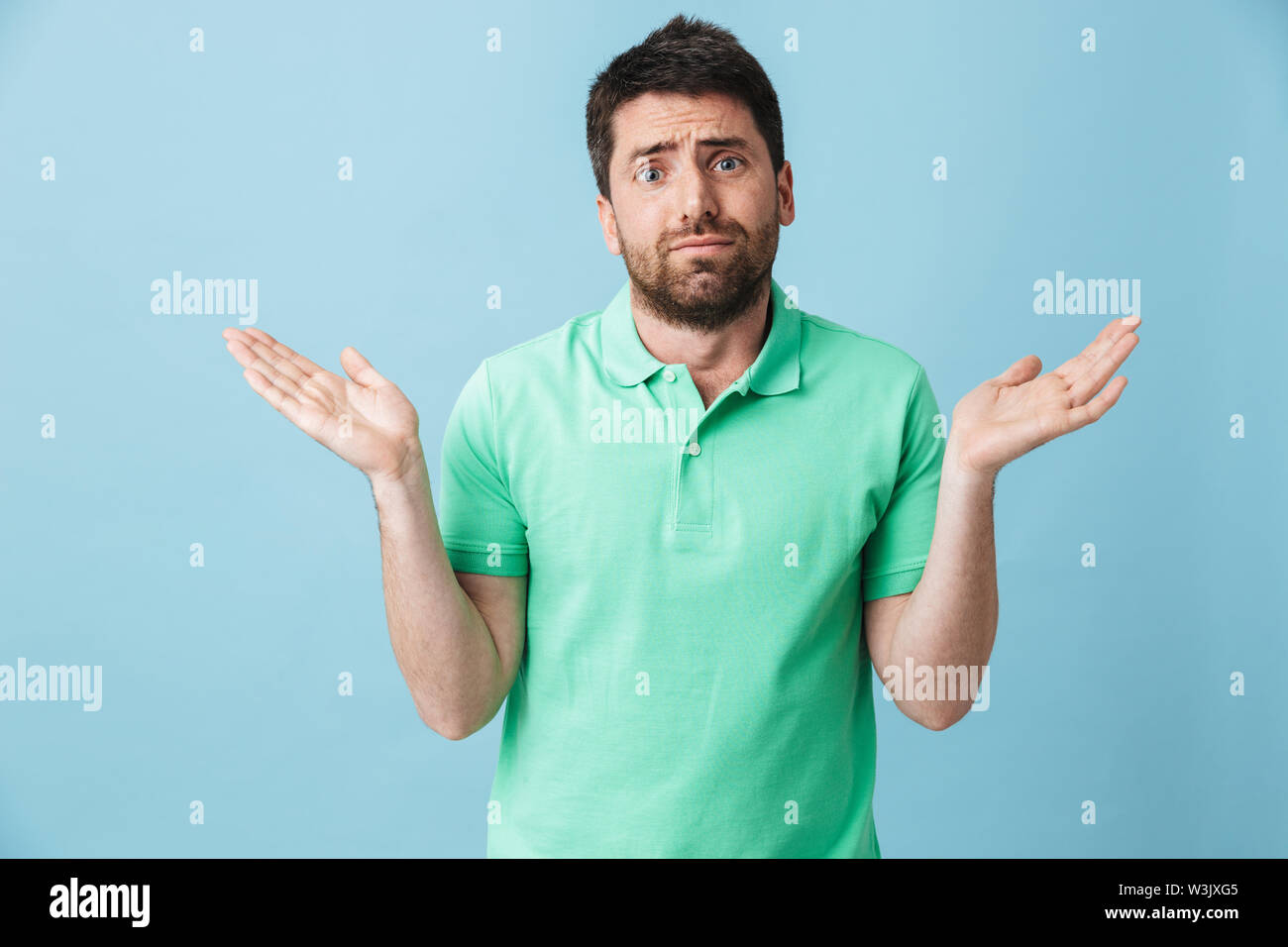 Photo of a confused young handsome bearded man posing isolated over ...