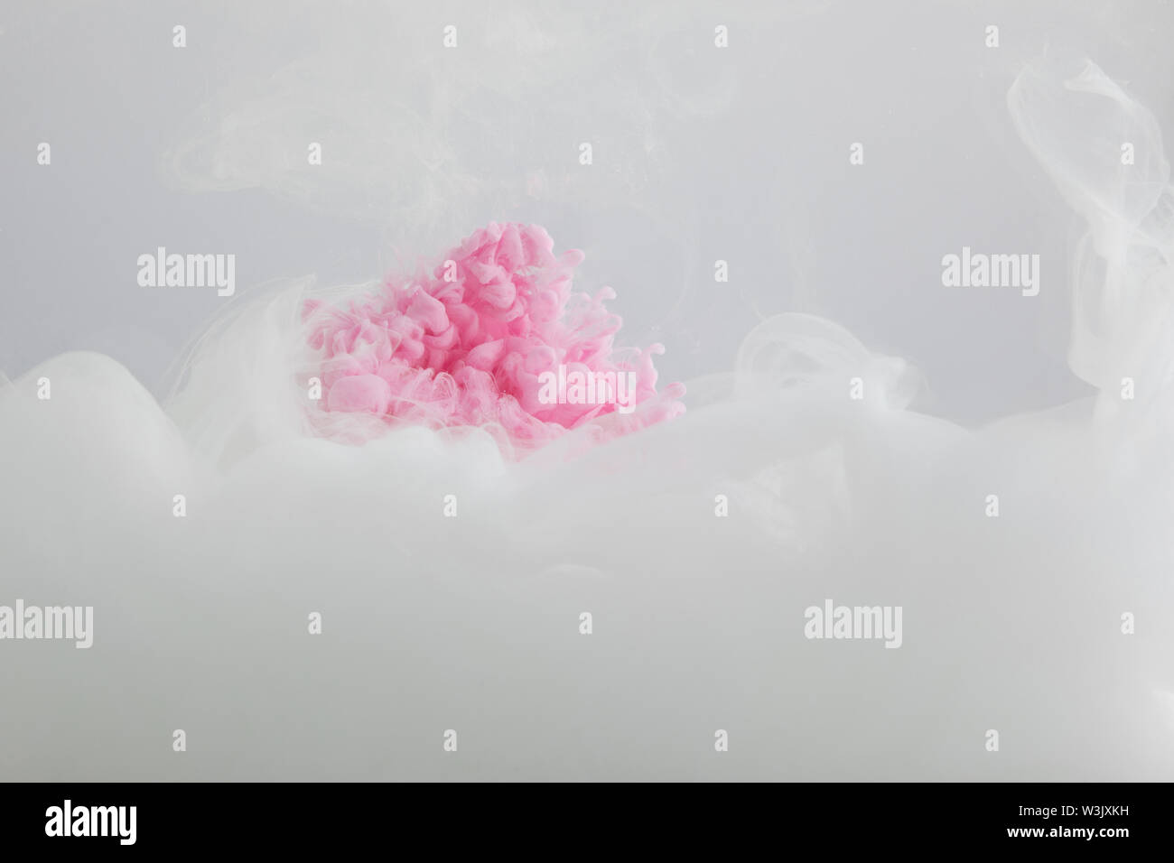 Close up view of pink and white paint mixing isolated on grey Stock ...