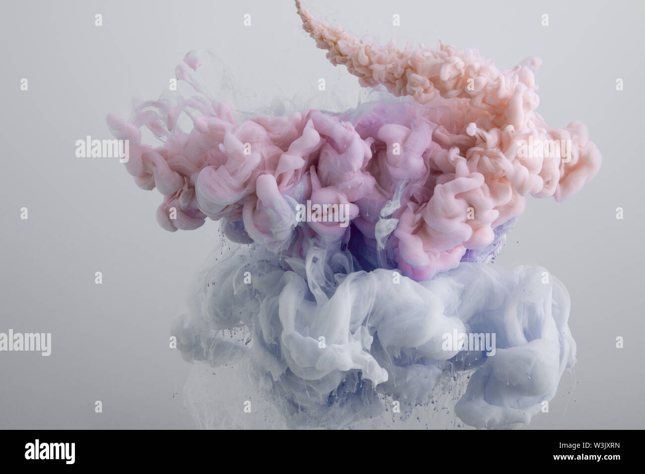 Close up view of light pink and blue paint swirls isolated on grey ...