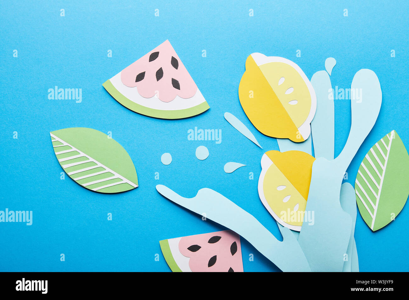 top view of paper cut water splash with lemons, leaves and watermelons ...
