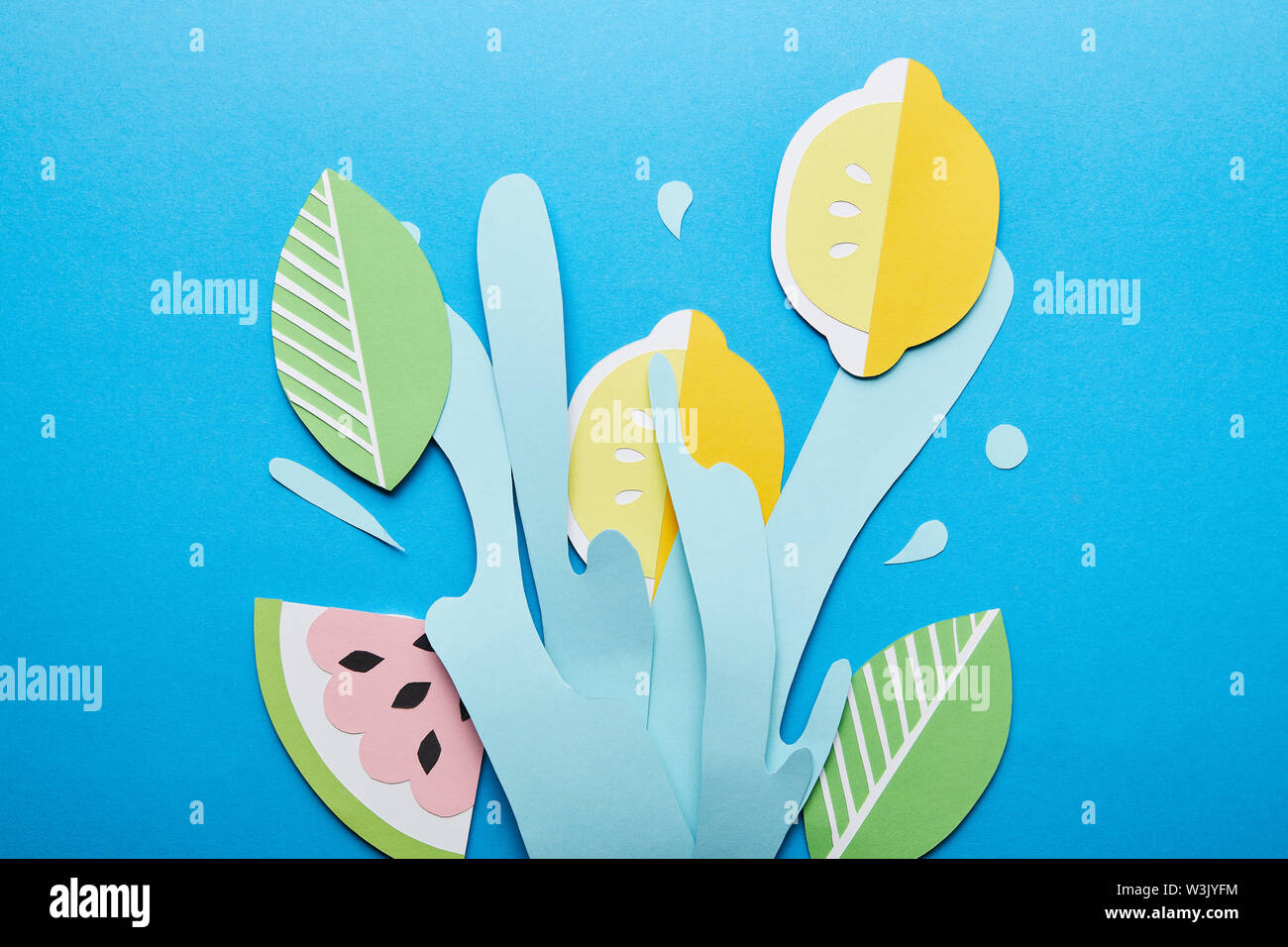 top view of paper cut water splash with lemons, leaves and watermelon ...