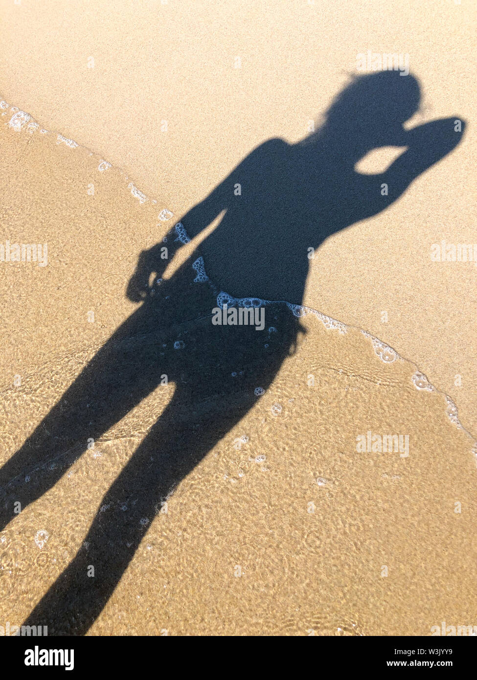 Young woman shadow on a sand Stock Photo - Alamy