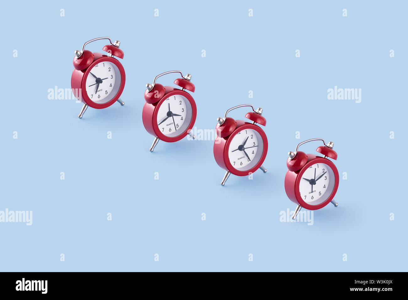 Classic red clock organized in a row over a blue background Stock Photo ...