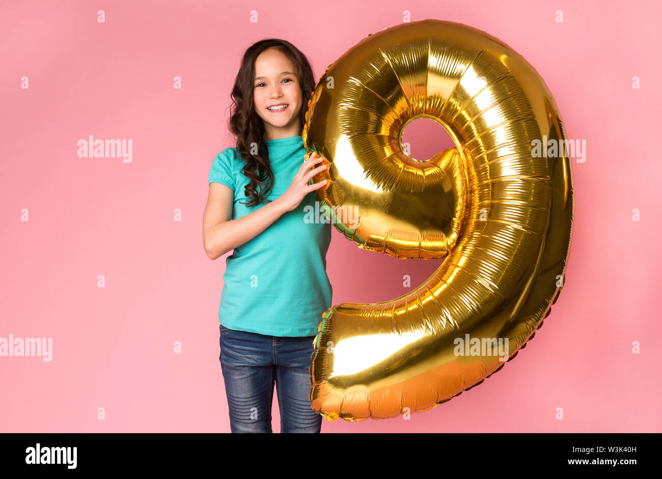 Cute girl with number 9 balloon at studio background Stock Photo - Alamy