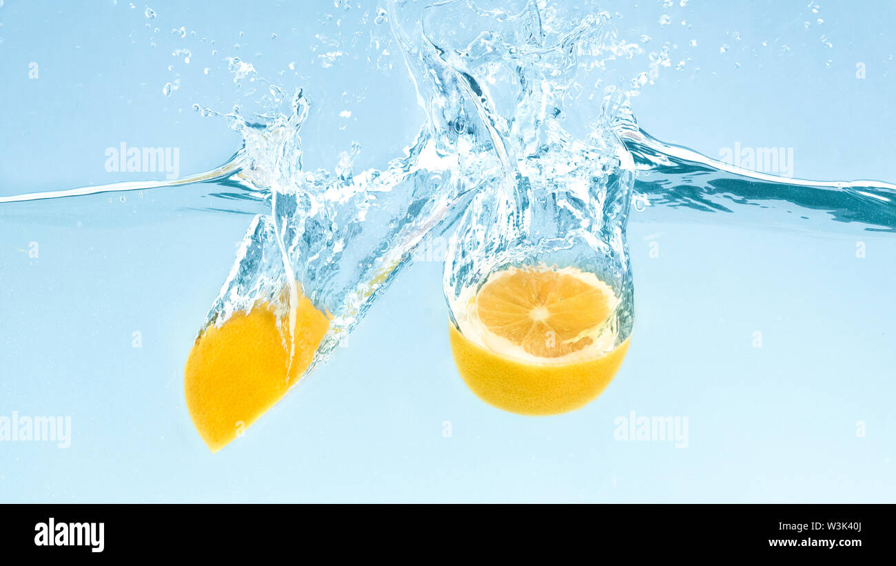 Cut fresh lemons in clear water with splash Stock Photo - Alamy