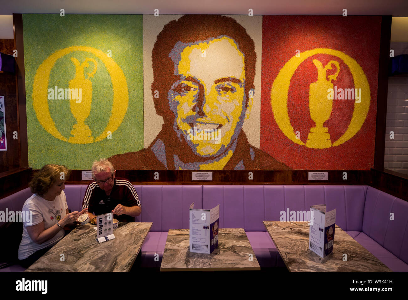 A couple sit eating ice-cream in Morelli's ice cream, in front of a ...