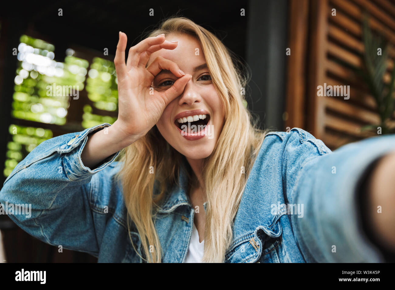 Image of amazing excited happy young woman posing outdoors in cafe take ...