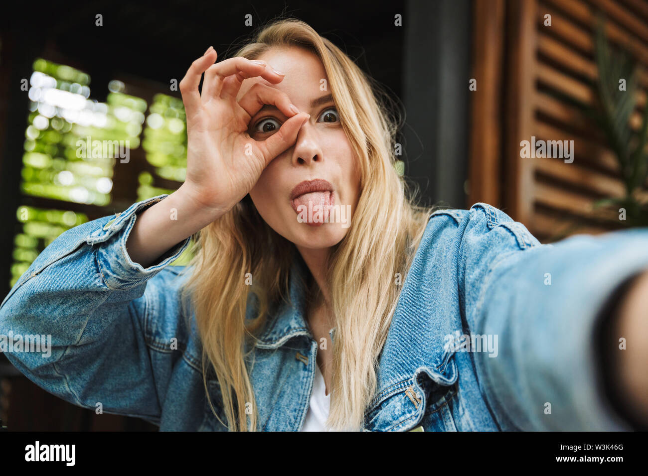 Image of amazing excited happy young woman posing outdoors in cafe take ...