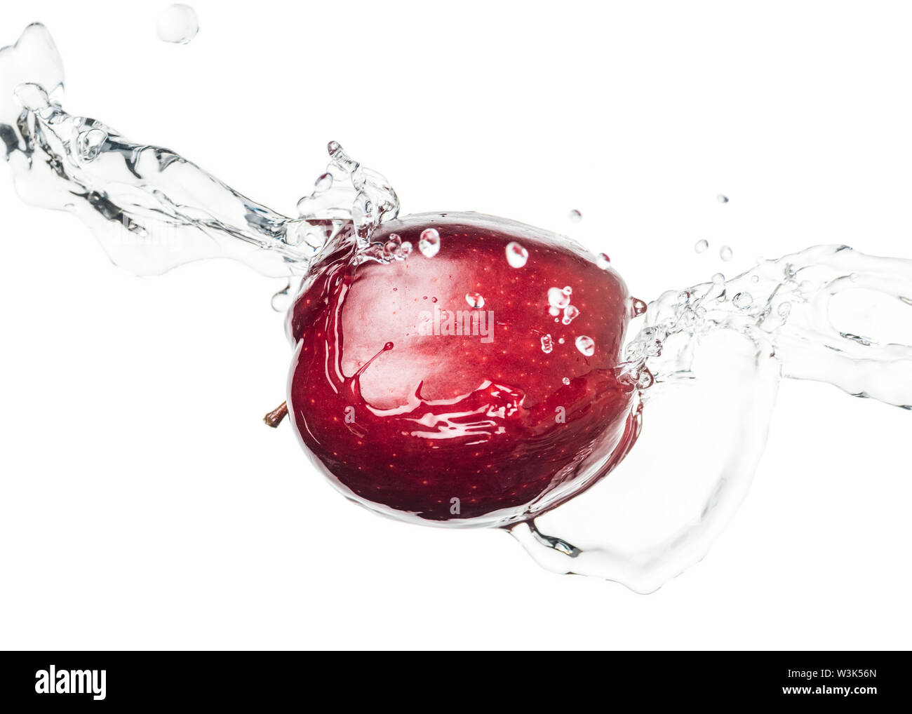 whole ripe red apple and clear water splash with drops isolated on ...