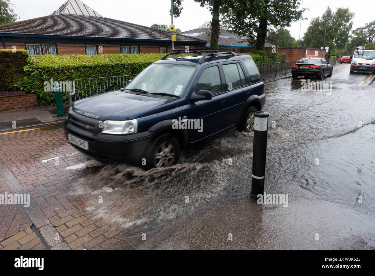 Cars drive through deep collected water following intense rainfall ...