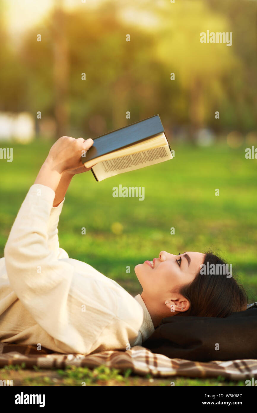 Relaxing in park. Girl reading book on grass Stock Photo - Alamy