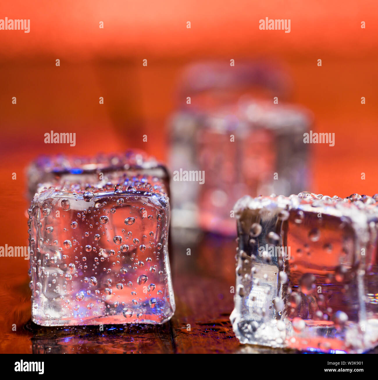 Melting ice cubes with droplets of water on a wooden background Stock ...