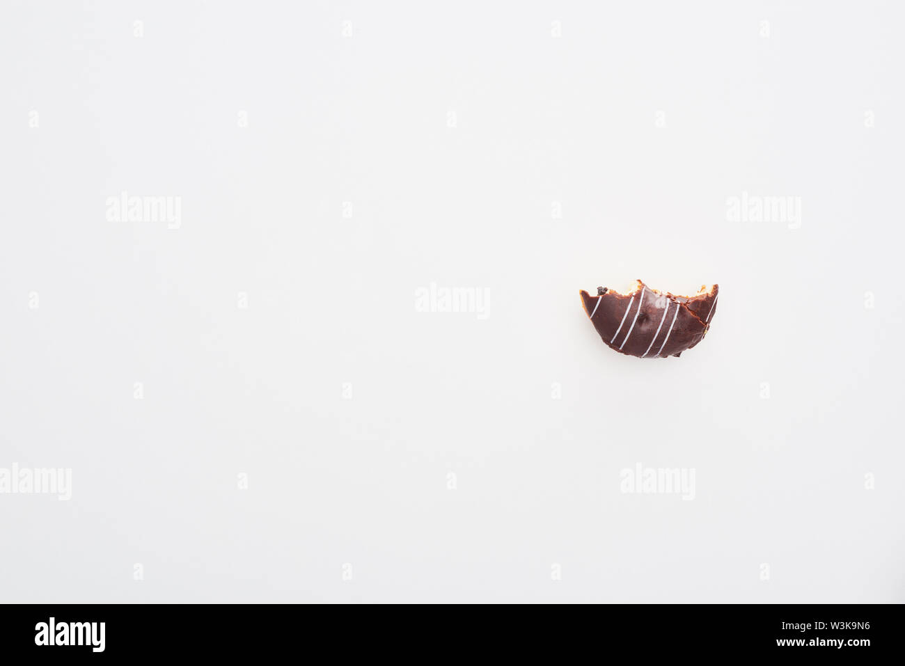 top view of bitten chocolate doughnut on white background with copy ...