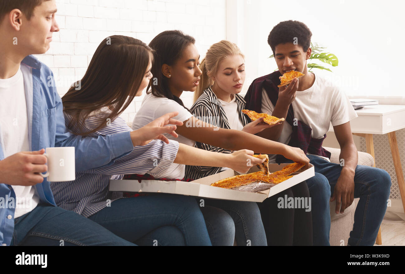 Home party. Teen friends eating pizza and talking Stock Photo - Alamy