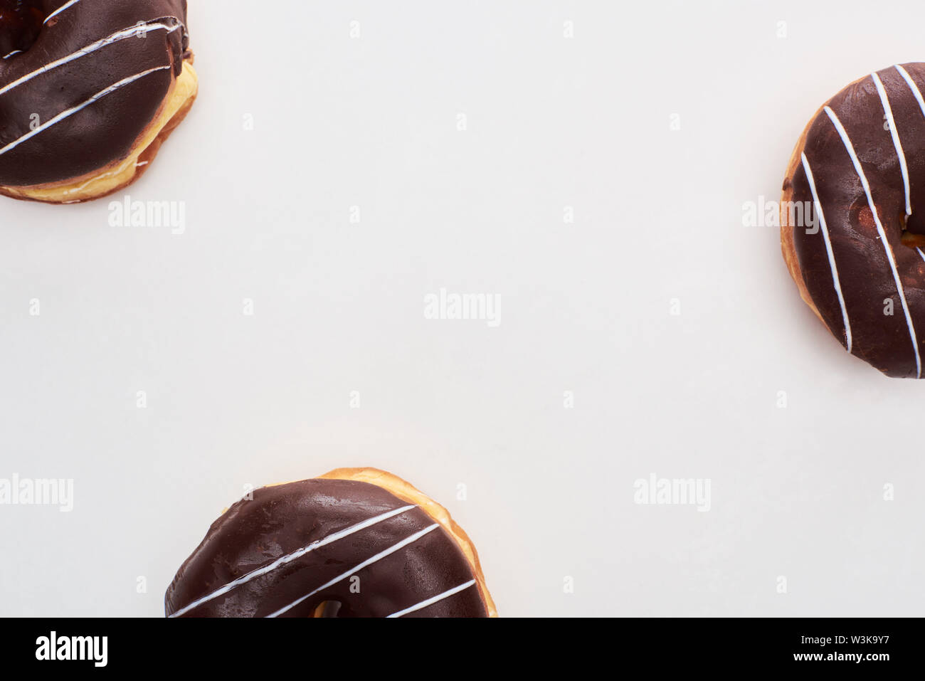 top view of chocolate glazed doughnuts on white background Stock Photo ...