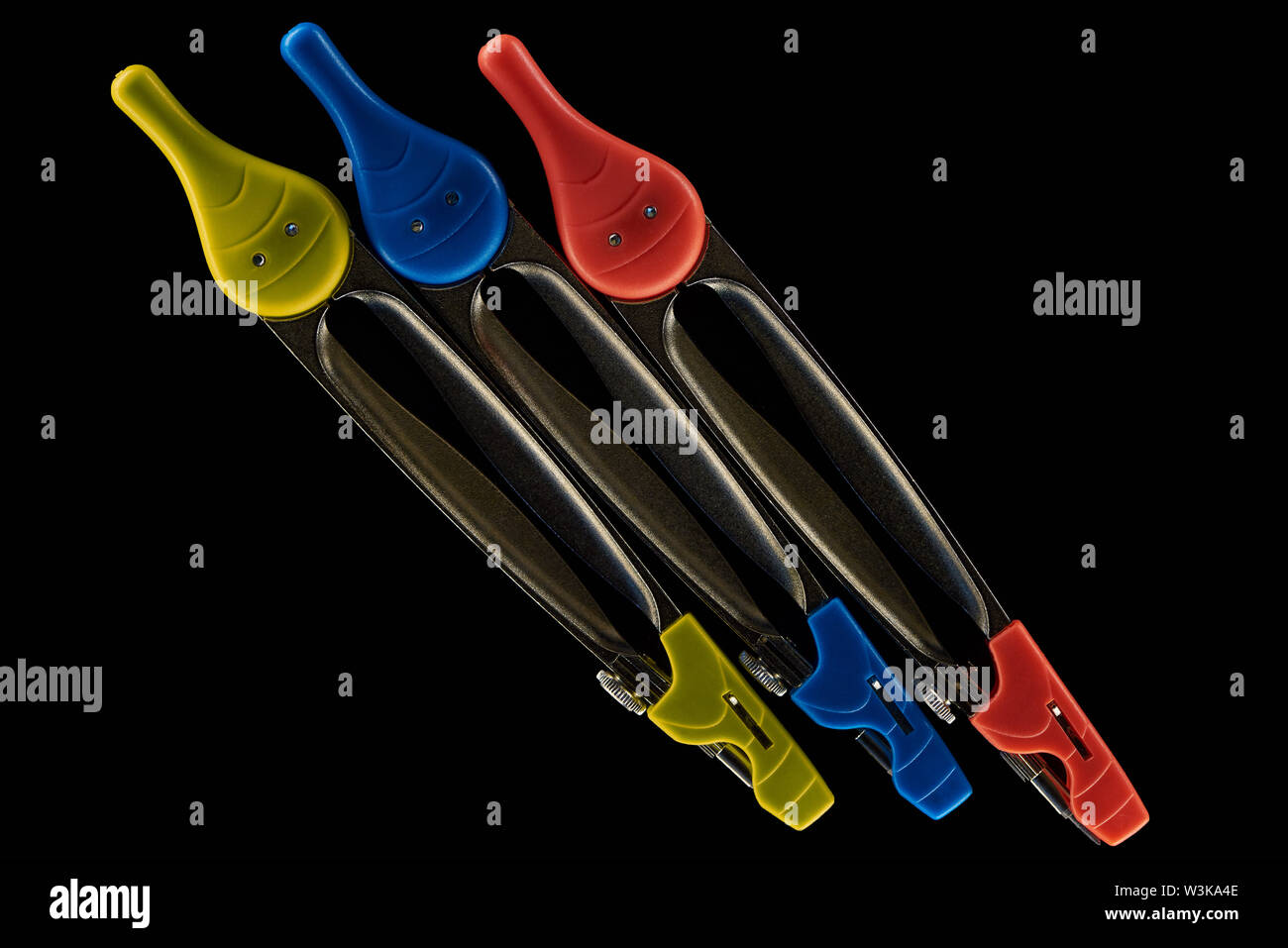 top view of yellow, blue and red compasses isolated on black Stock ...