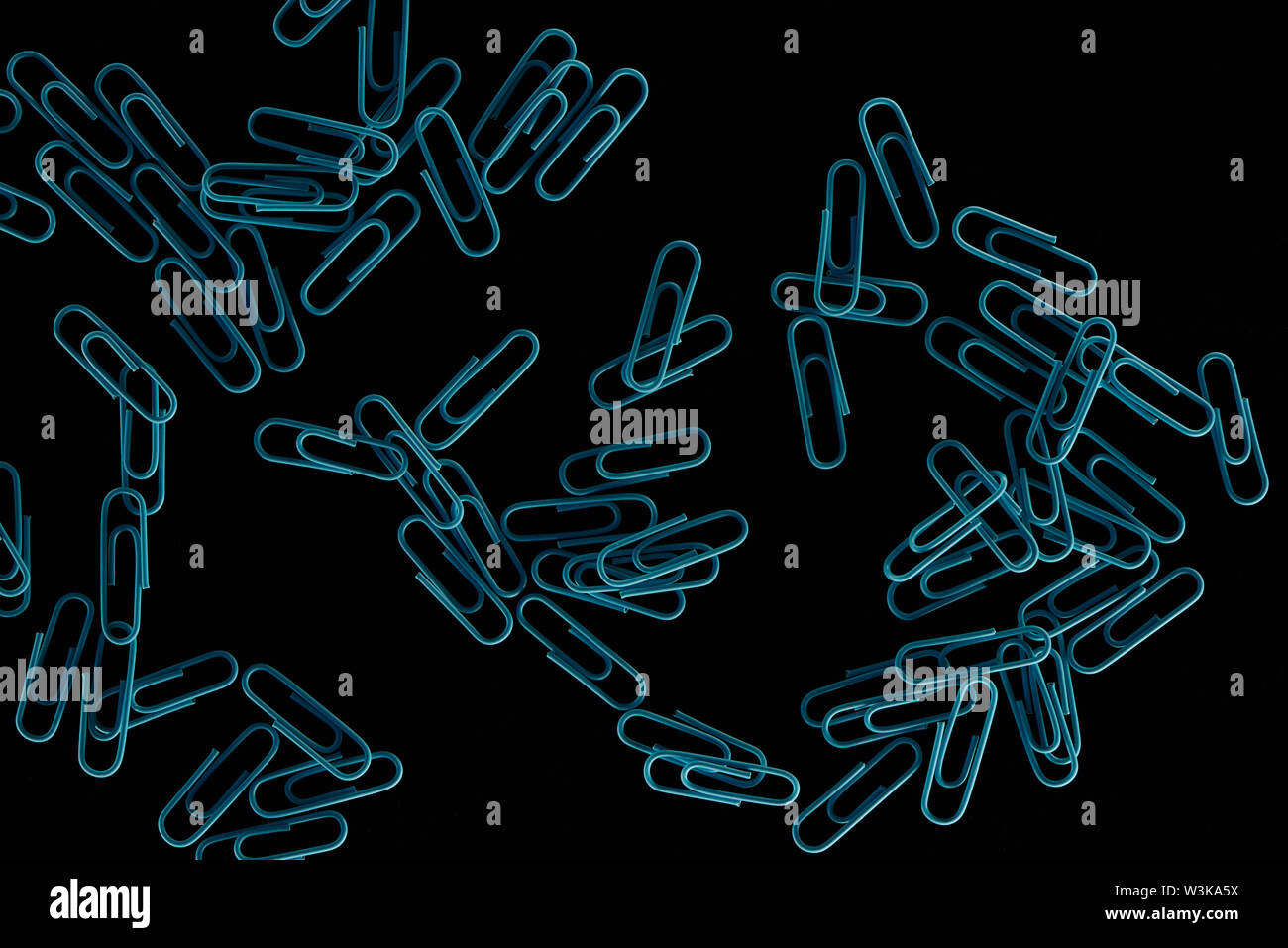 scattered blue paper clips isolated on black Stock Photo - Alamy