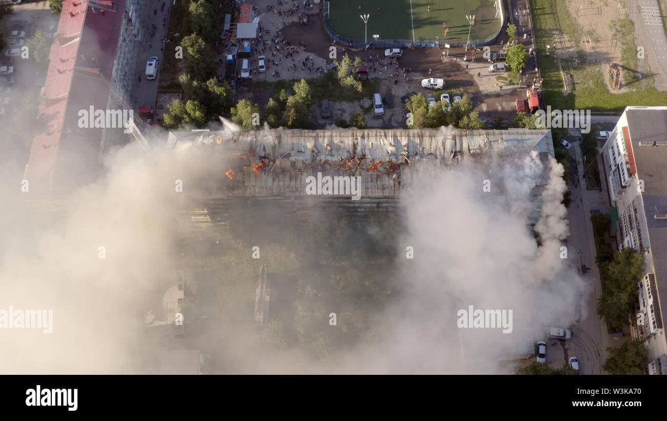 Burning roof of a residential high-rise building, clouds of smoke from ...