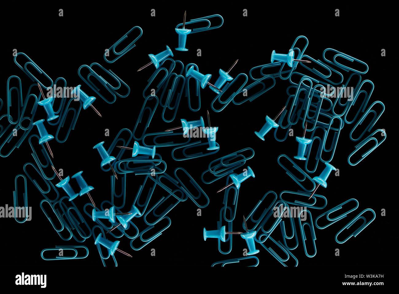 top view two kinds of scattered blue paper clips isolated on black ...