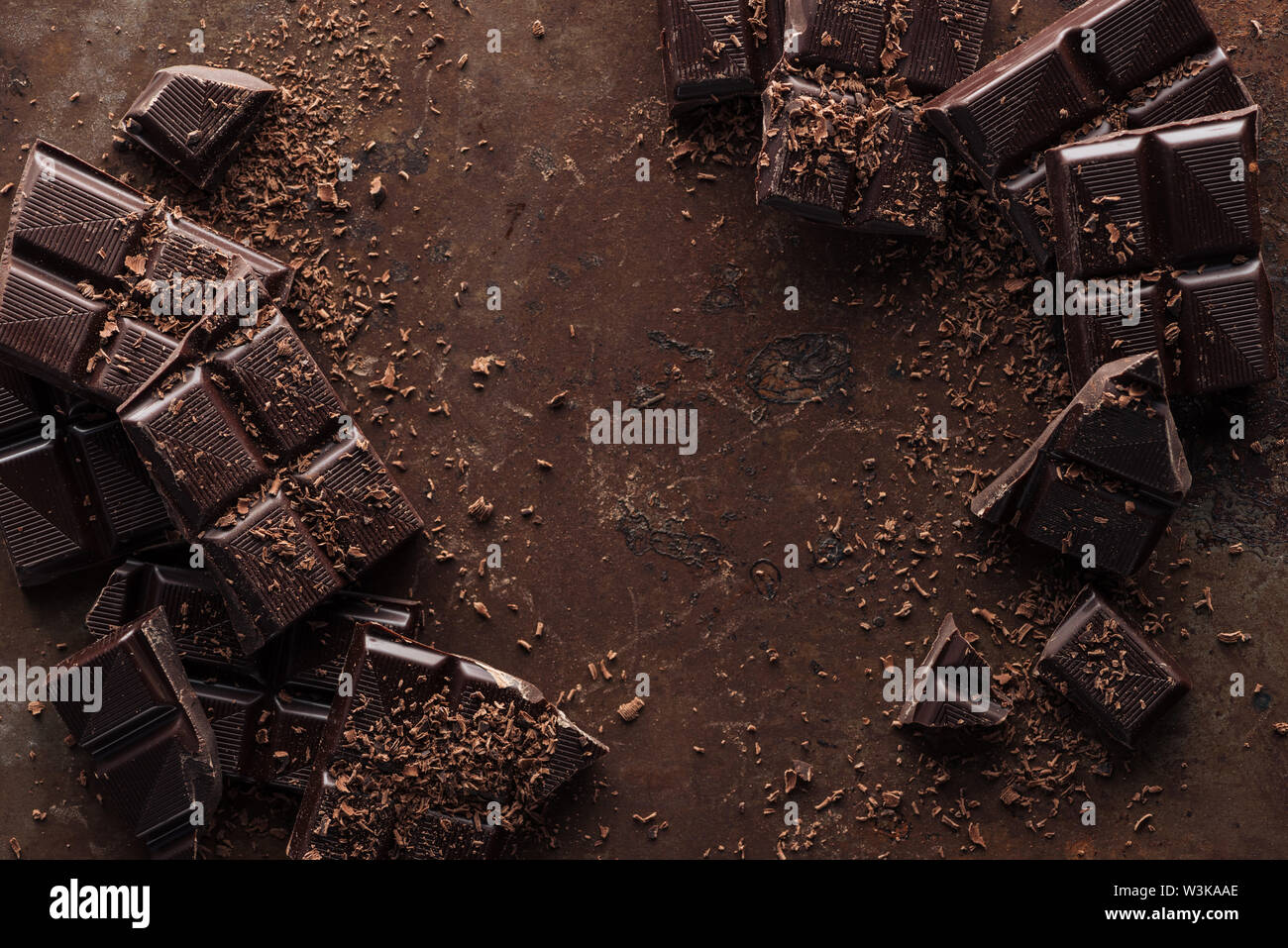 Top view of pieces of chocolate bar with chocolate chips on rust metal ...
