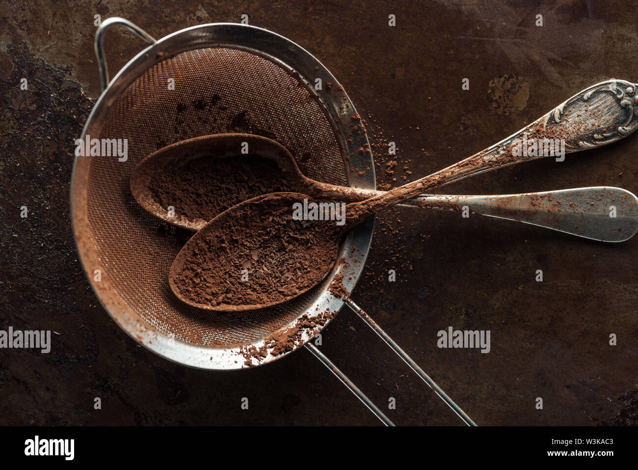 Top view of dirty strainer and vintage spoons on rust metal background ...