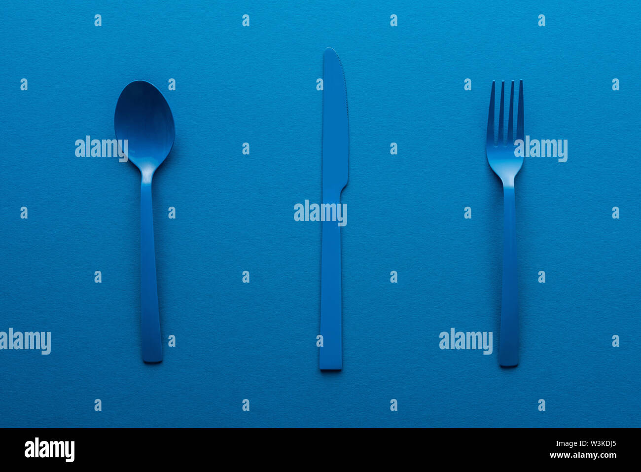 blue plastic spoon, knife and fork on blue background Stock Photo - Alamy