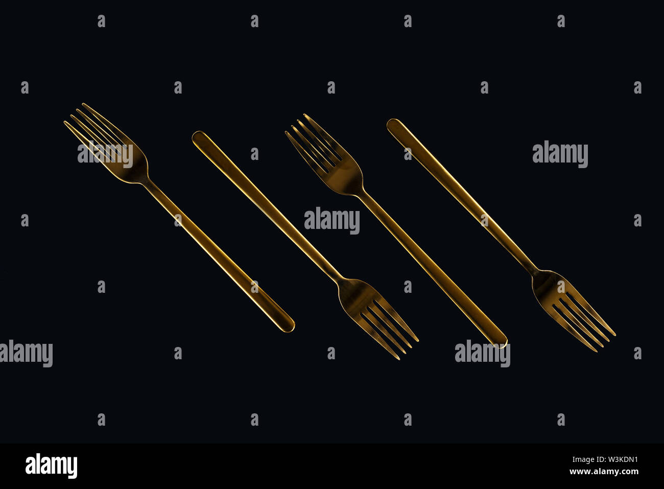 four metal forks isolated on black Stock Photo - Alamy