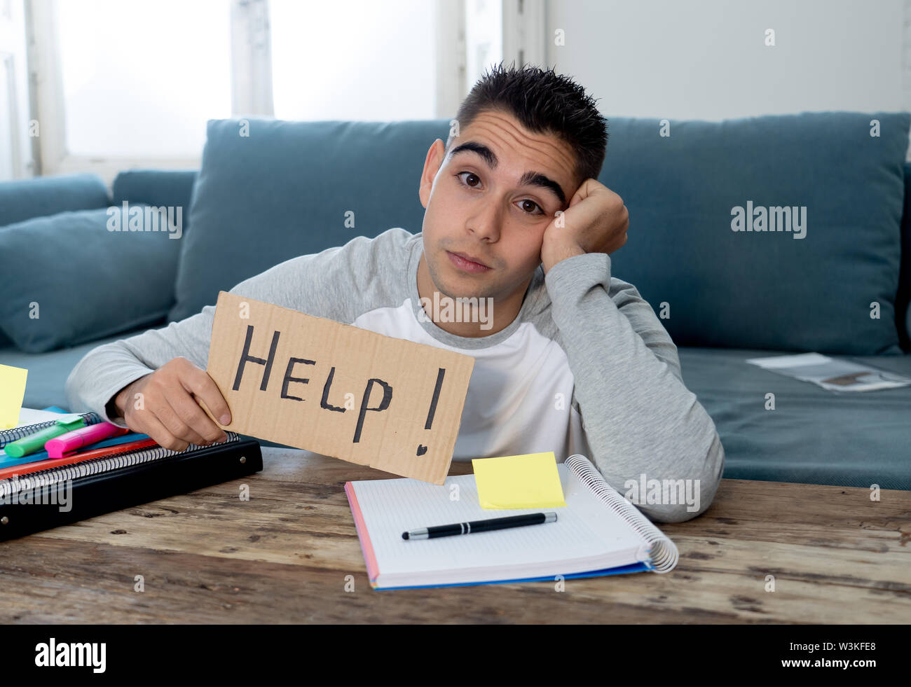 Young tired and stressed student working on his homework, masters ...