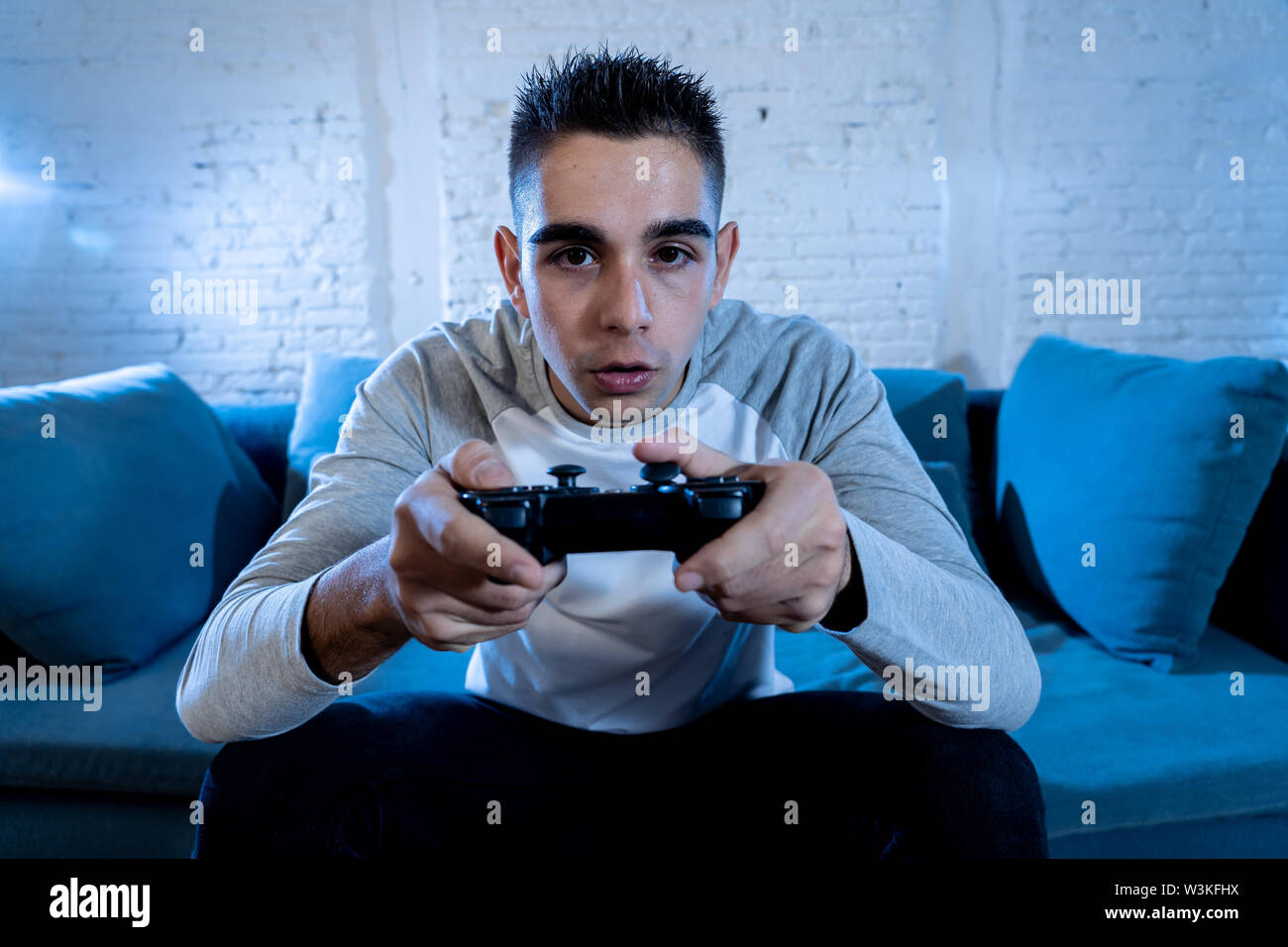 Portrait of young student man playing video games at night using ...