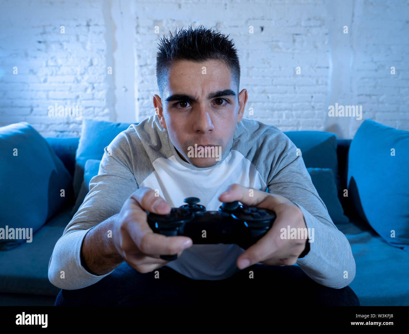 Portrait of young student man playing video games at night using ...