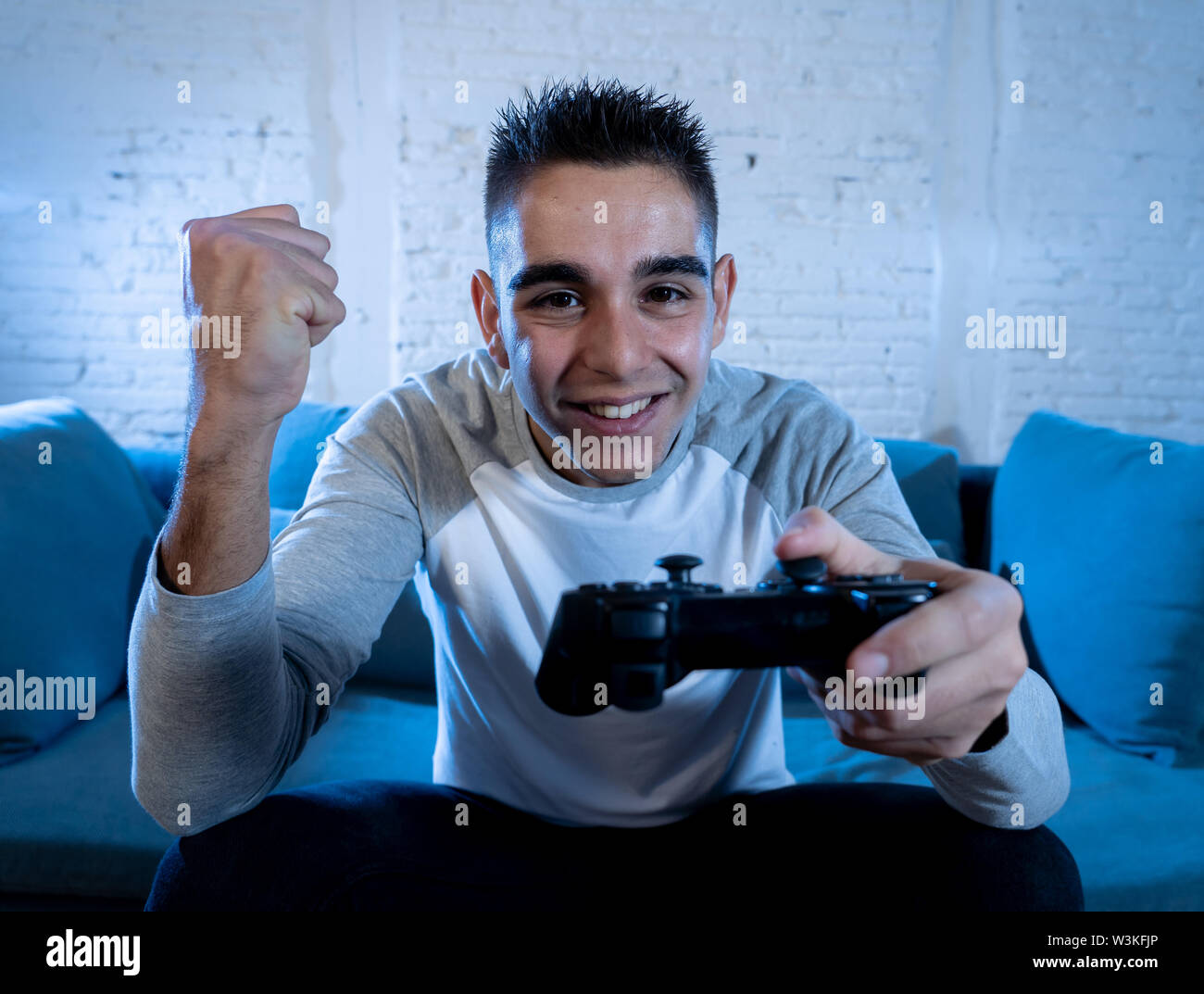 Portrait of young man having fun playing video games using wireless ...
