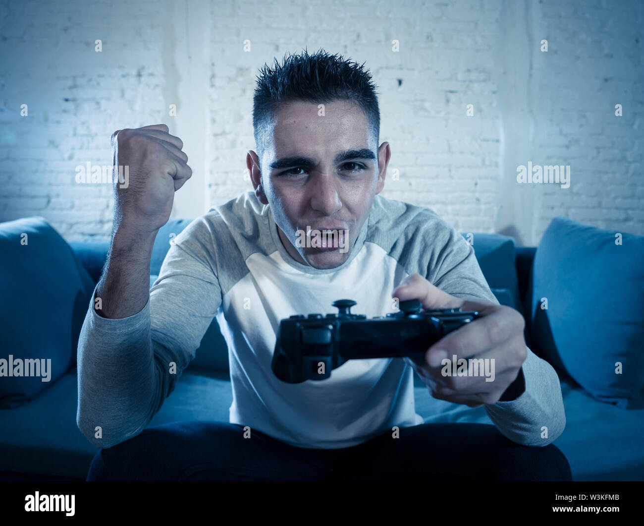 Portrait of young man having fun playing video games using wireless ...