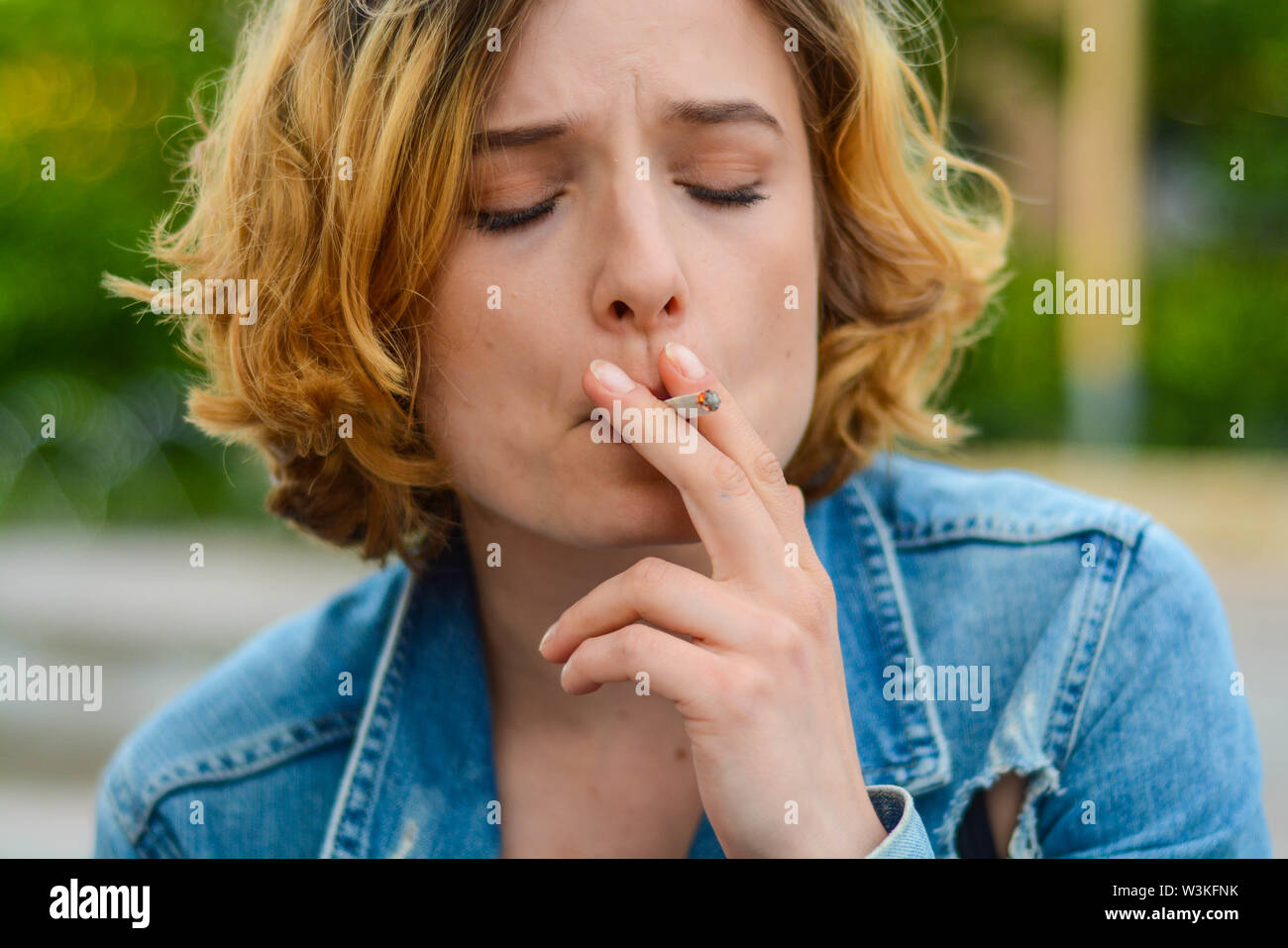 Lady smoking a cigarette hi-res stock photography and images - Alamy