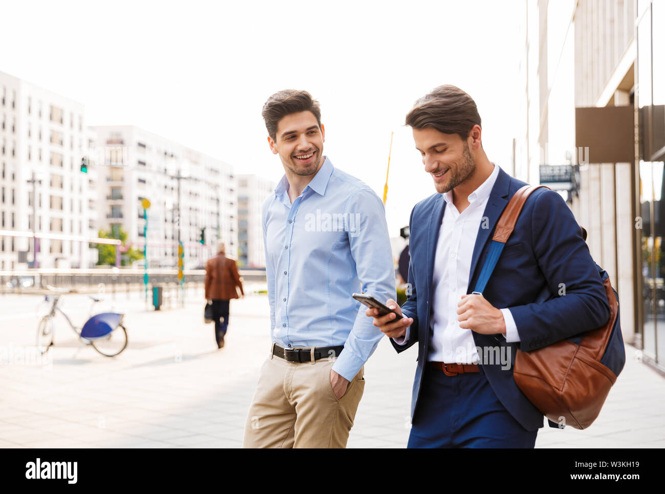 Image of a cheerful happy young two friends colleagues business men ...