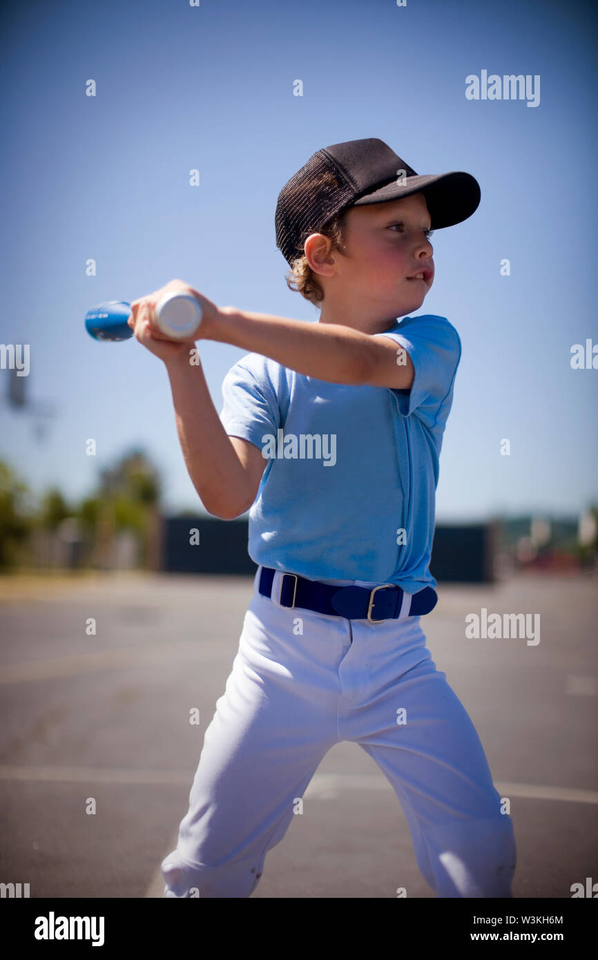 Young boy swinging a baseball bat Stock Photo - Alamy