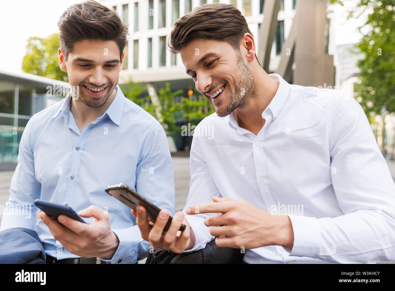 Image of a cheerful happy young two friends colleagues business men ...