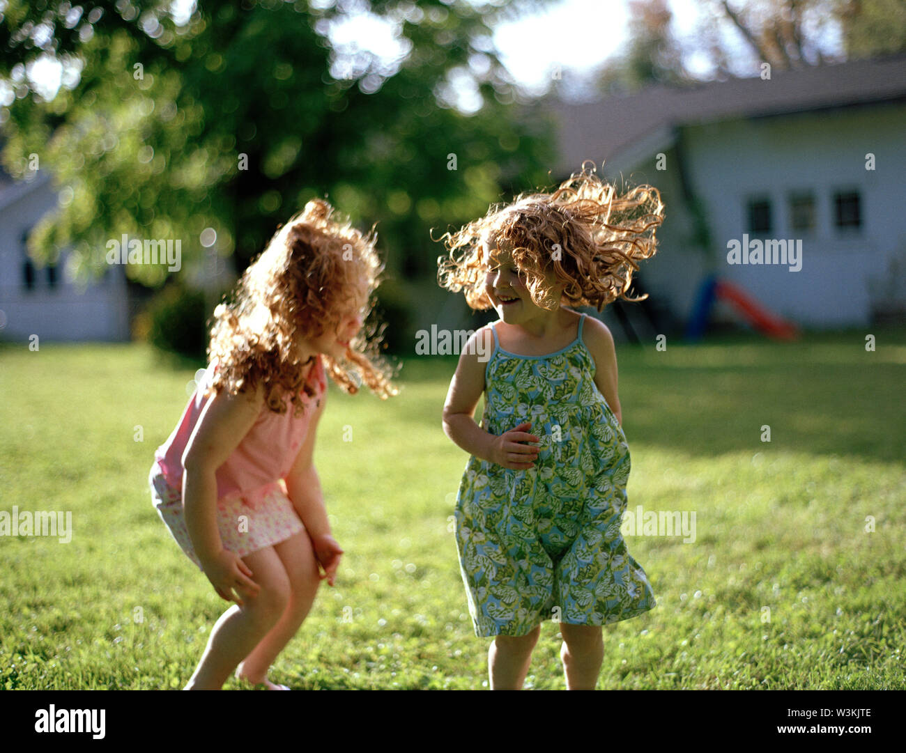 Little girls playing in the garden Stock Photo - Alamy