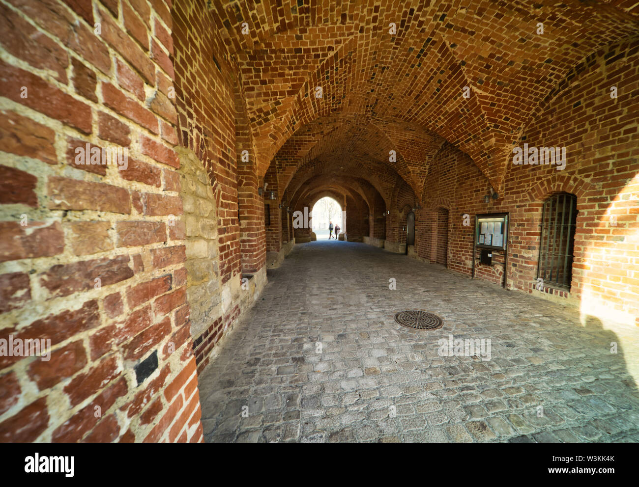 Bricked archway made of red bricks as a passage between the two wings ...