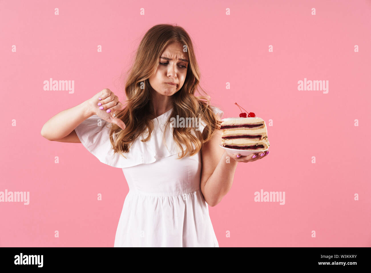 Image of disappointed young woman wearing white dress biting her lip ...